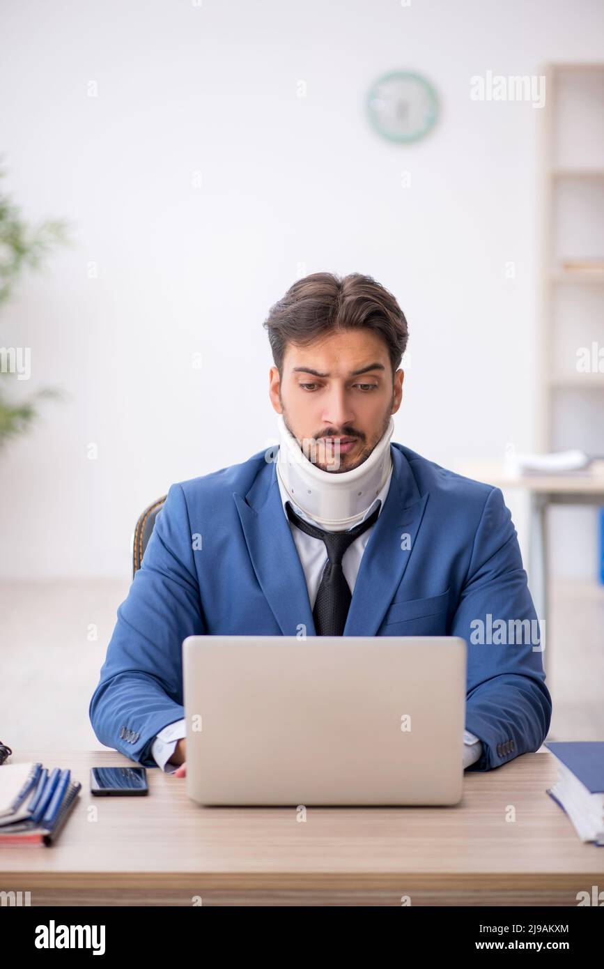 Young neck injured businessman employee at workplace Stock Photo - Alamy