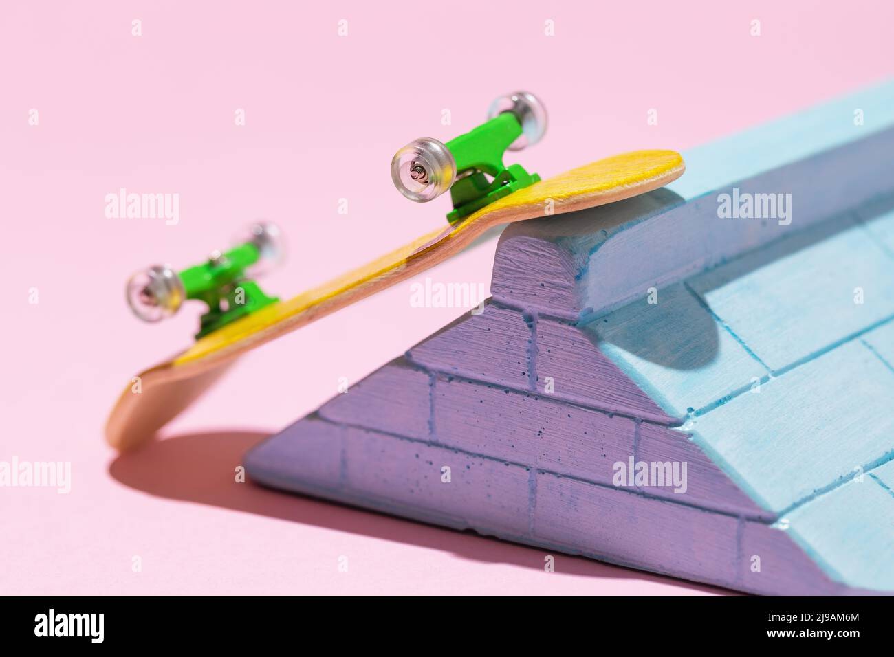 Yellow fingerboard and plaster ramp on a pink background Stock Photo ...
