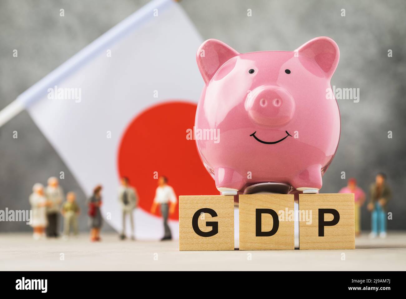 Piggy bank, wooden cubes with text, toy people made of plastic and a ...