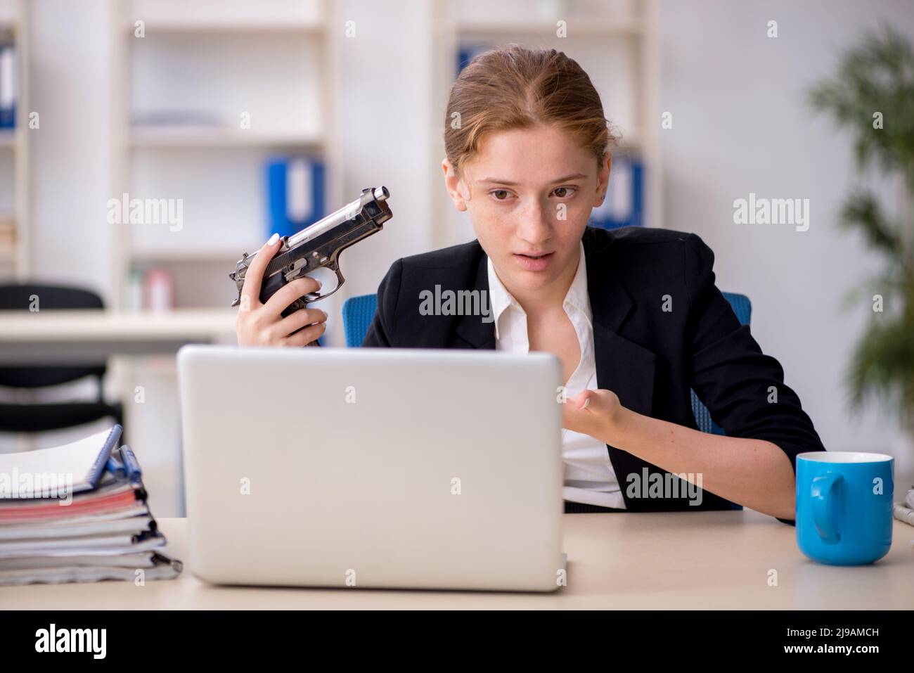 Female employee holding gun at workplace Stock Photo - Alamy