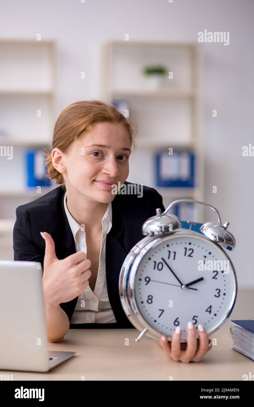 Female employee in time management concept Stock Photo - Alamy