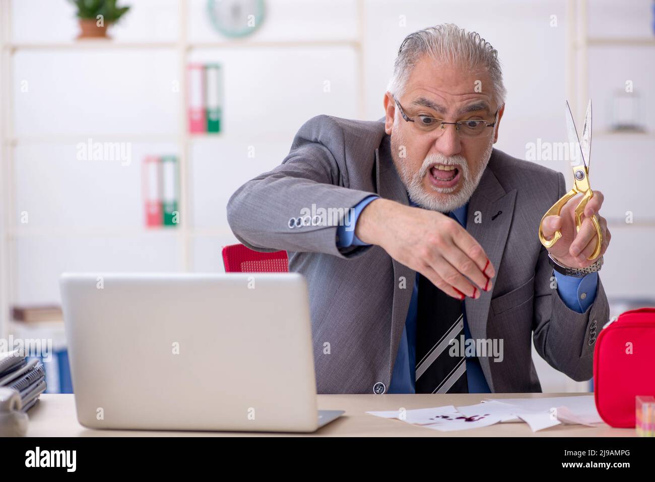 Old businessman employee cutting his hand at workplace Stock Photo - Alamy
