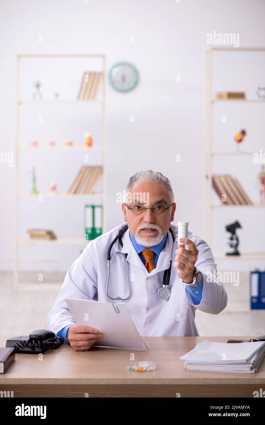 Old doctor working in the clinic Stock Photo - Alamy