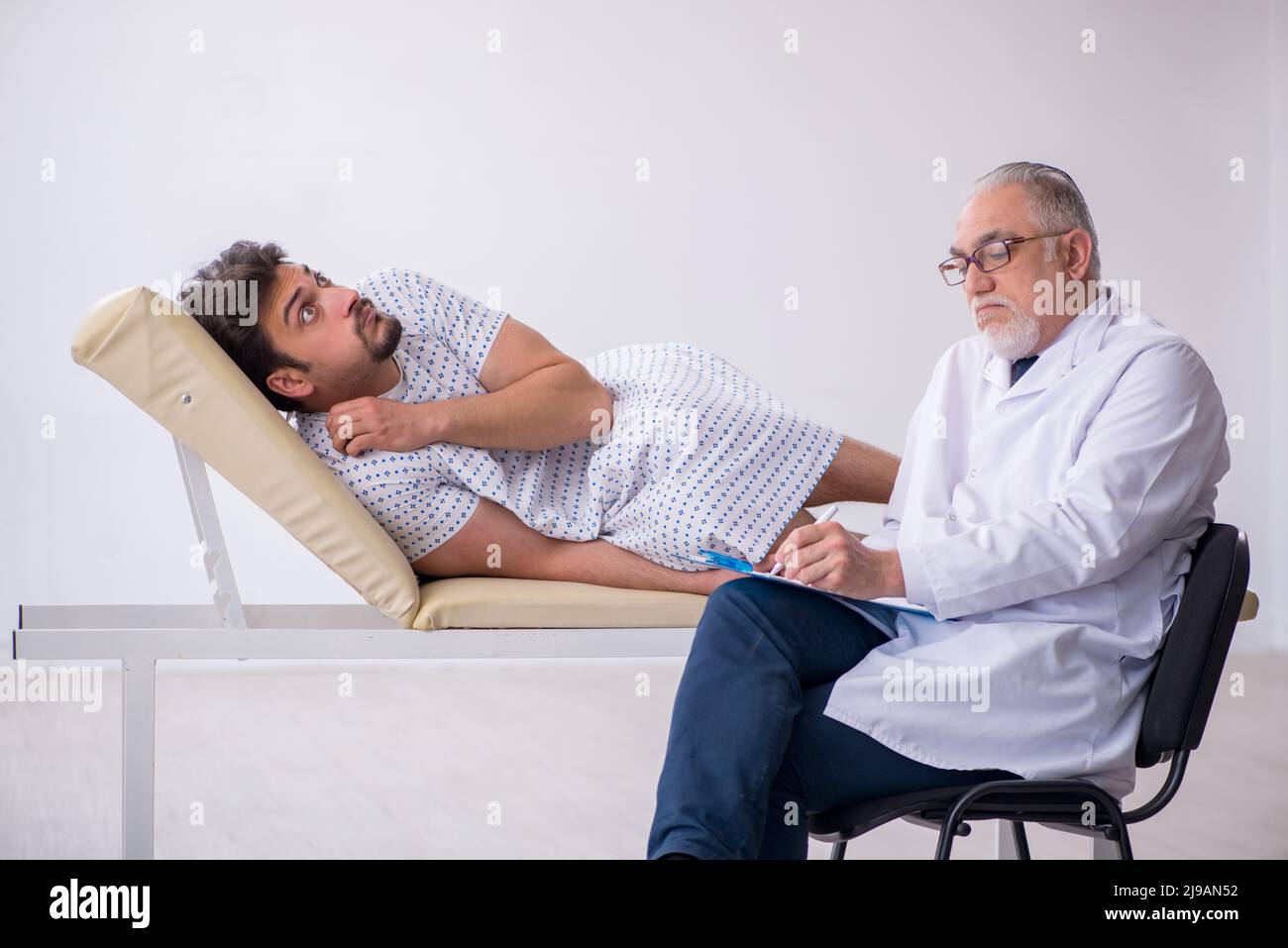 Old doctor psychiatrist examining young male patient Stock Photo - Alamy