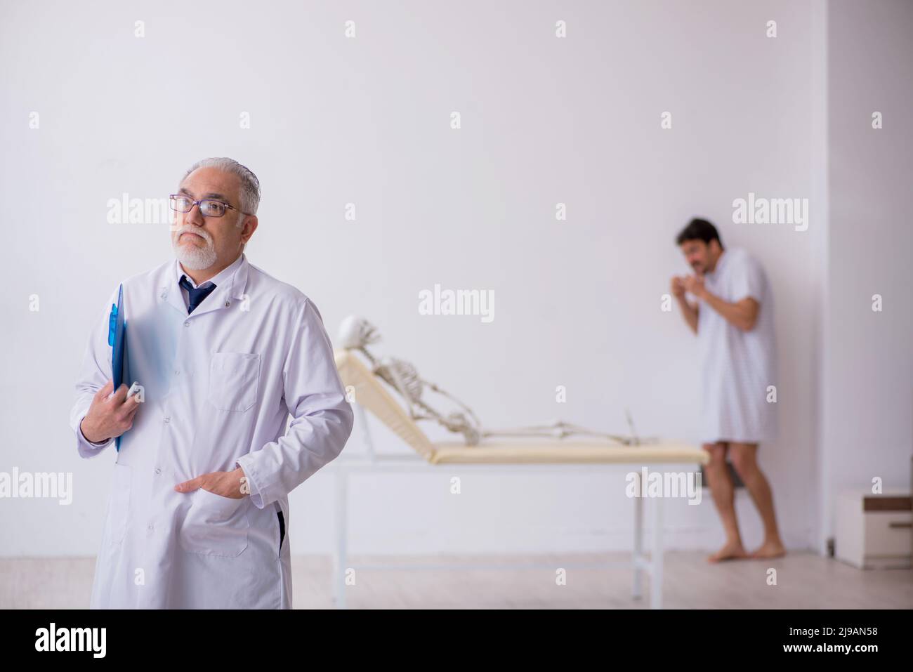 Old doctor psychiatrist examining young male patient Stock Photo - Alamy