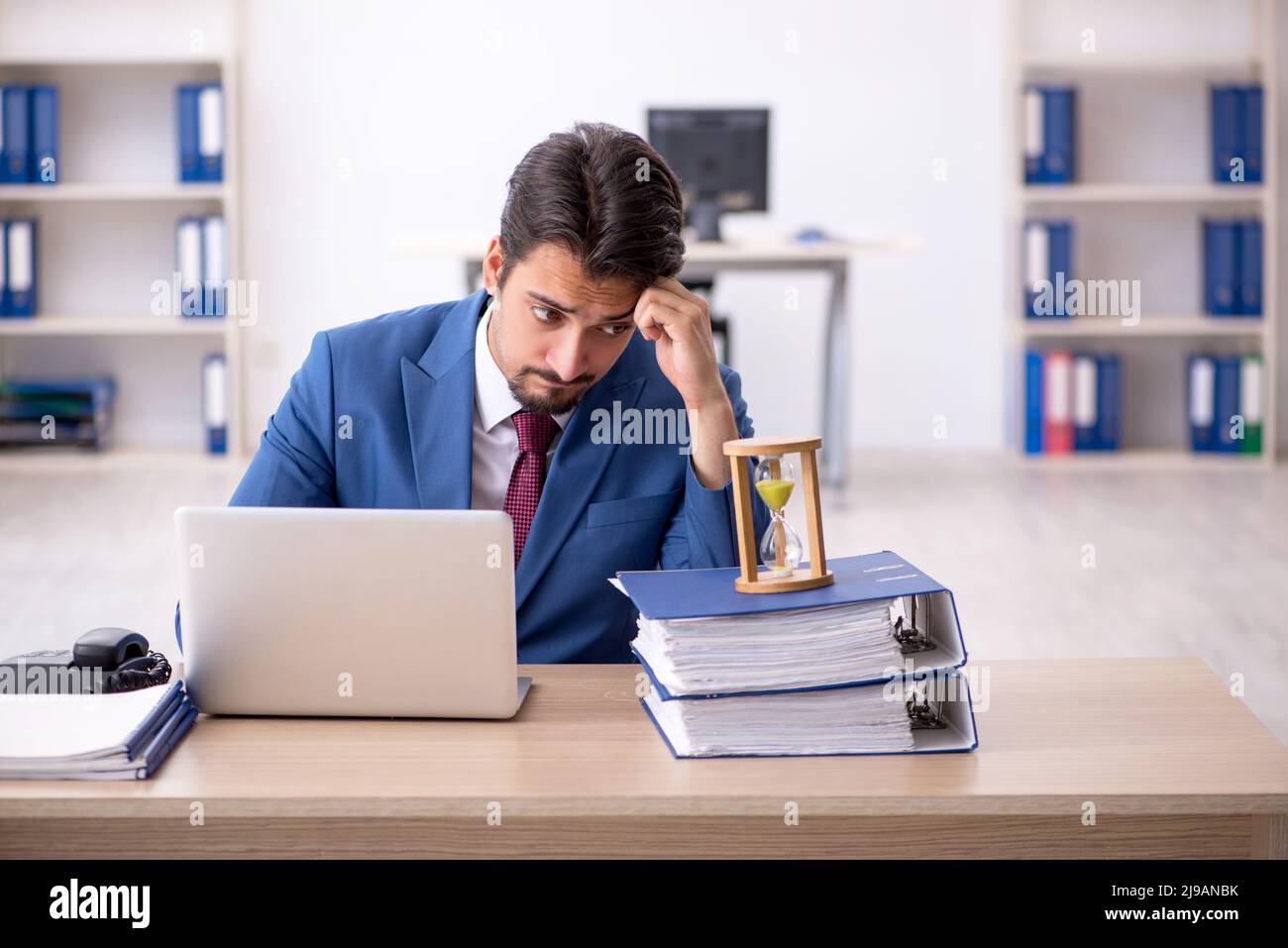 Young employee in time management concept Stock Photo - Alamy