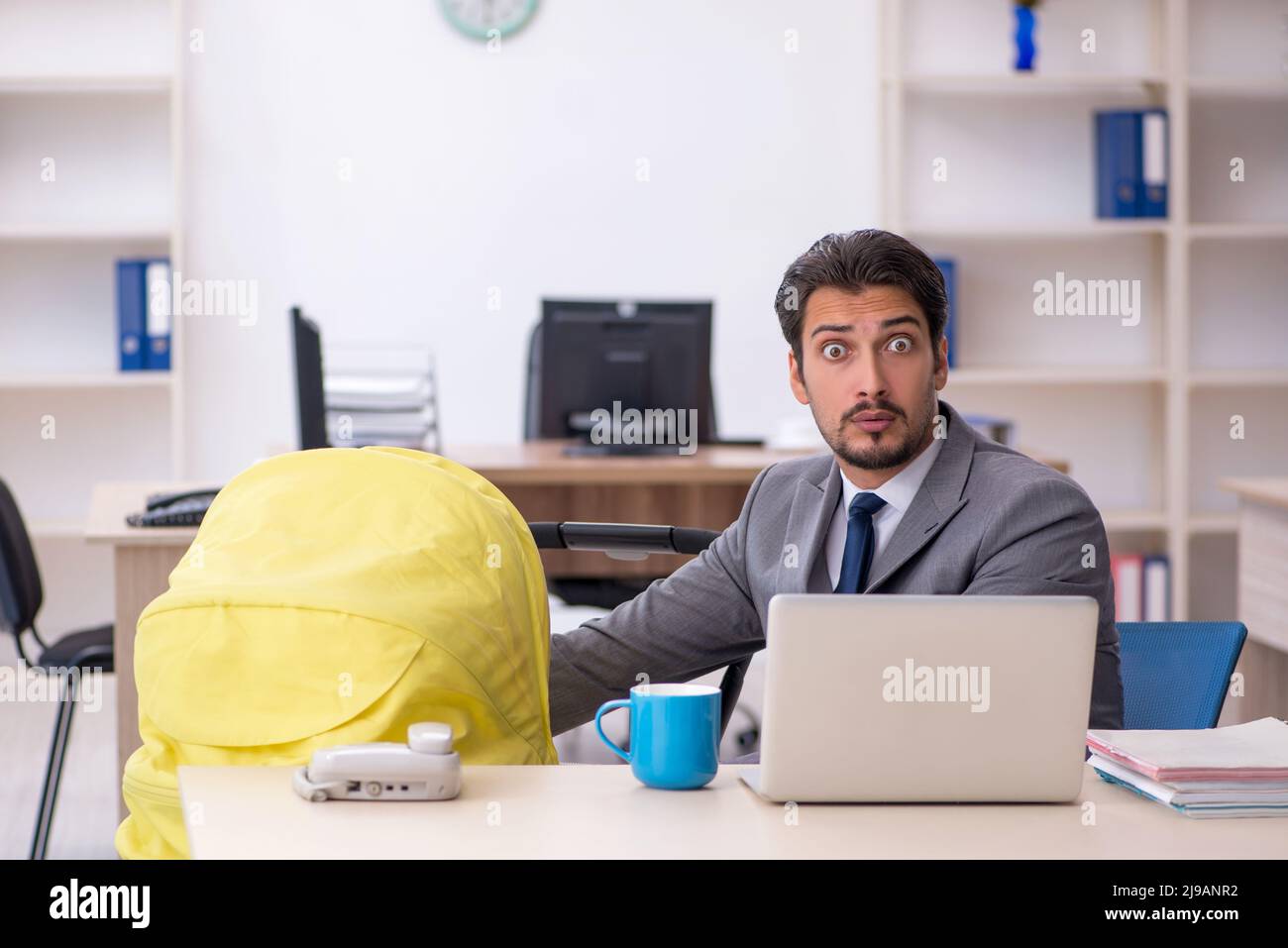 Young businessman employee looking after new born in the office Stock ...