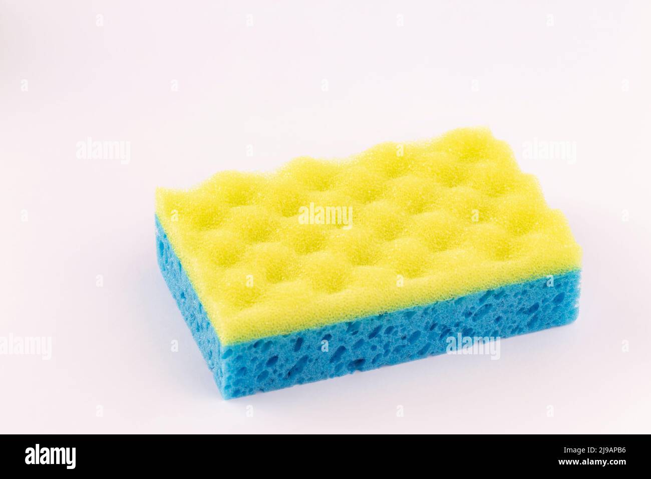 Yellow- blue sponge for washing dishes close-up isolated on white ...