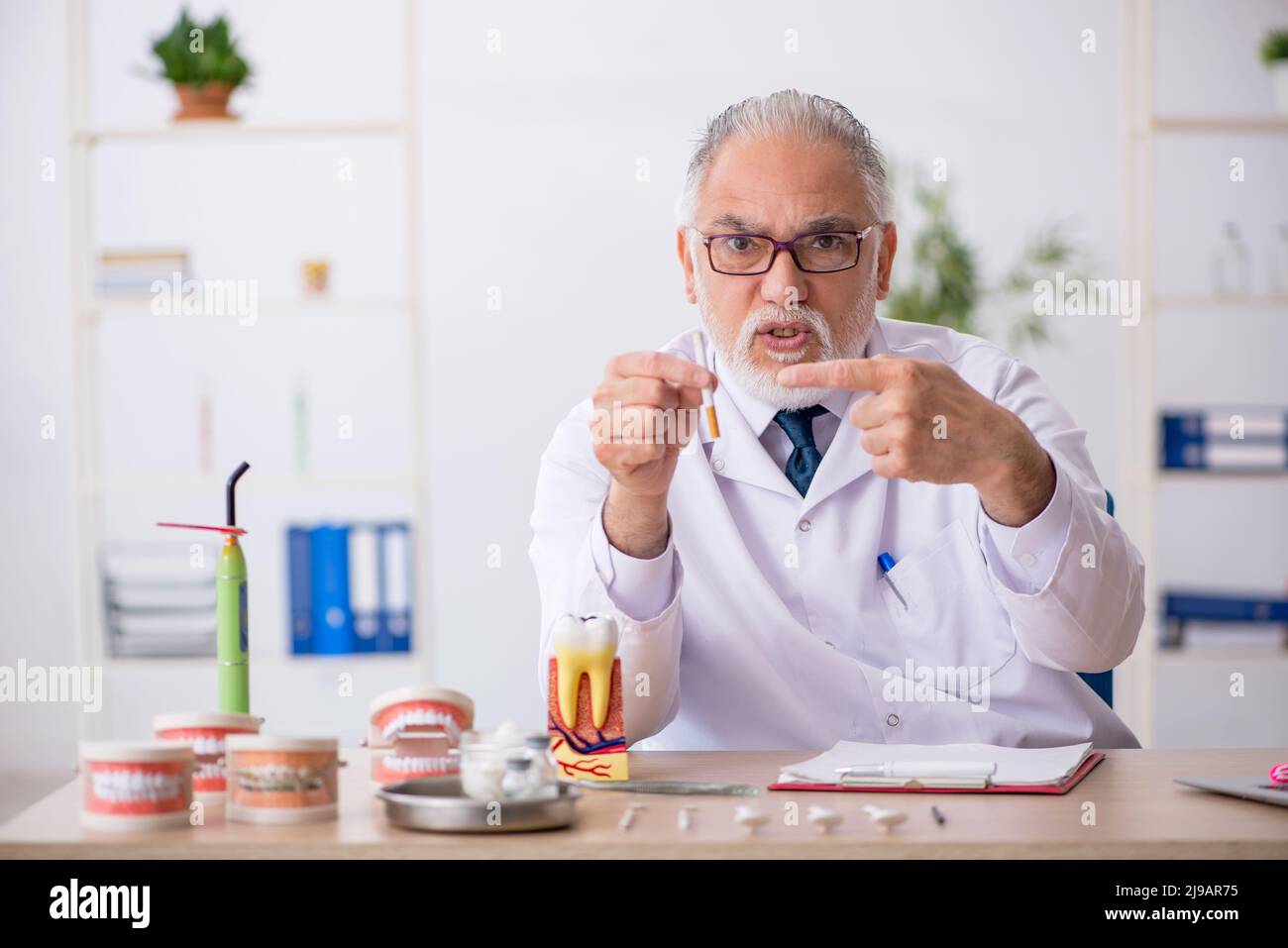 Old male doctor dentist working at the hospital Stock Photo - Alamy