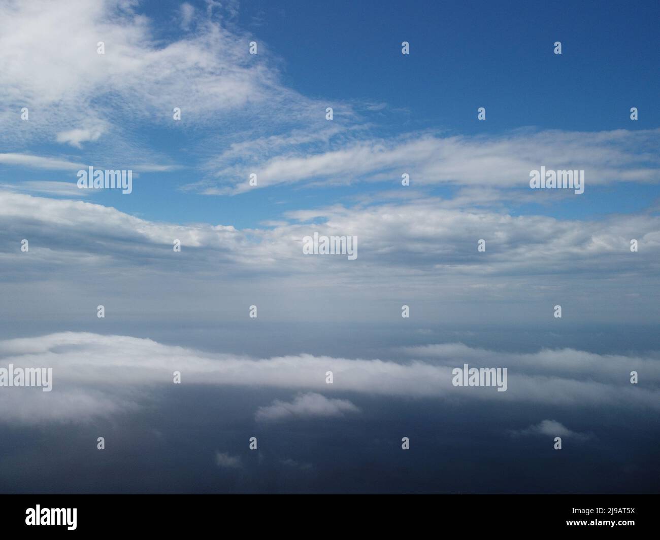 Aerial view. Blue sky sun and fog over calm sea. The drone flies over ...