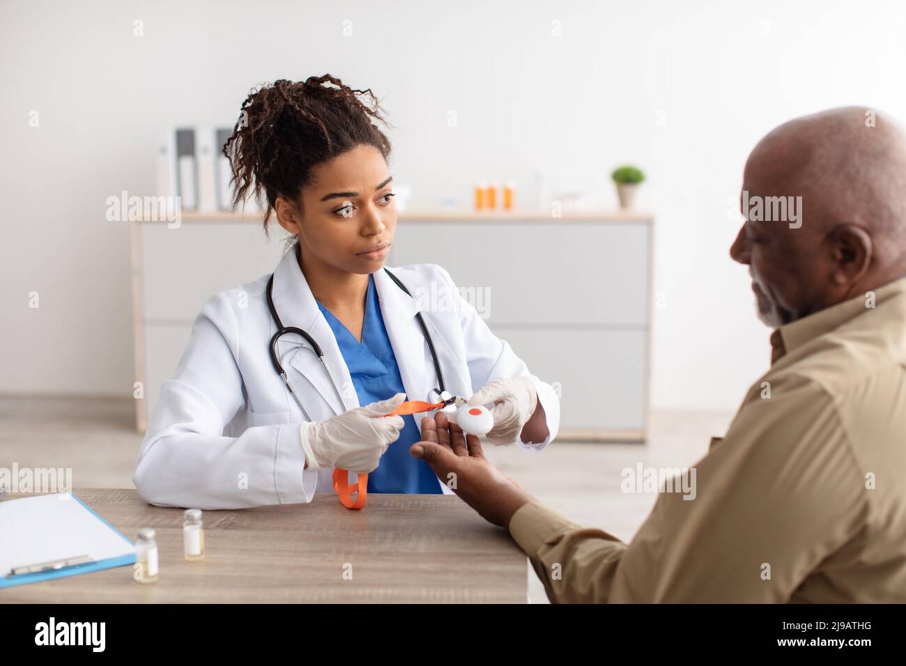 Emergency call system. Doctor giving Alarm Button to Senior Man Stock ...