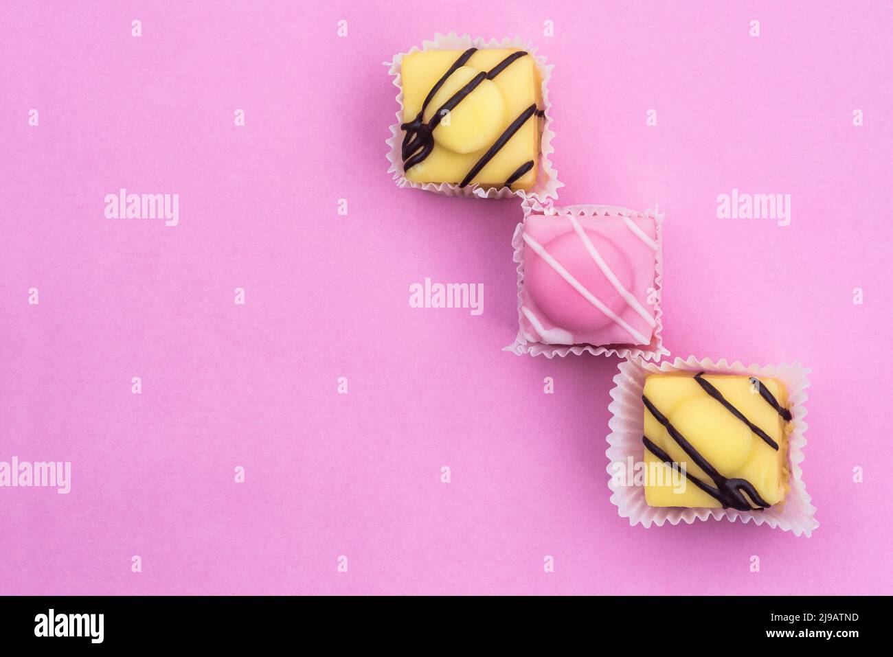 Fondant icing on sponge cakes set on a pastel pink background Stock ...