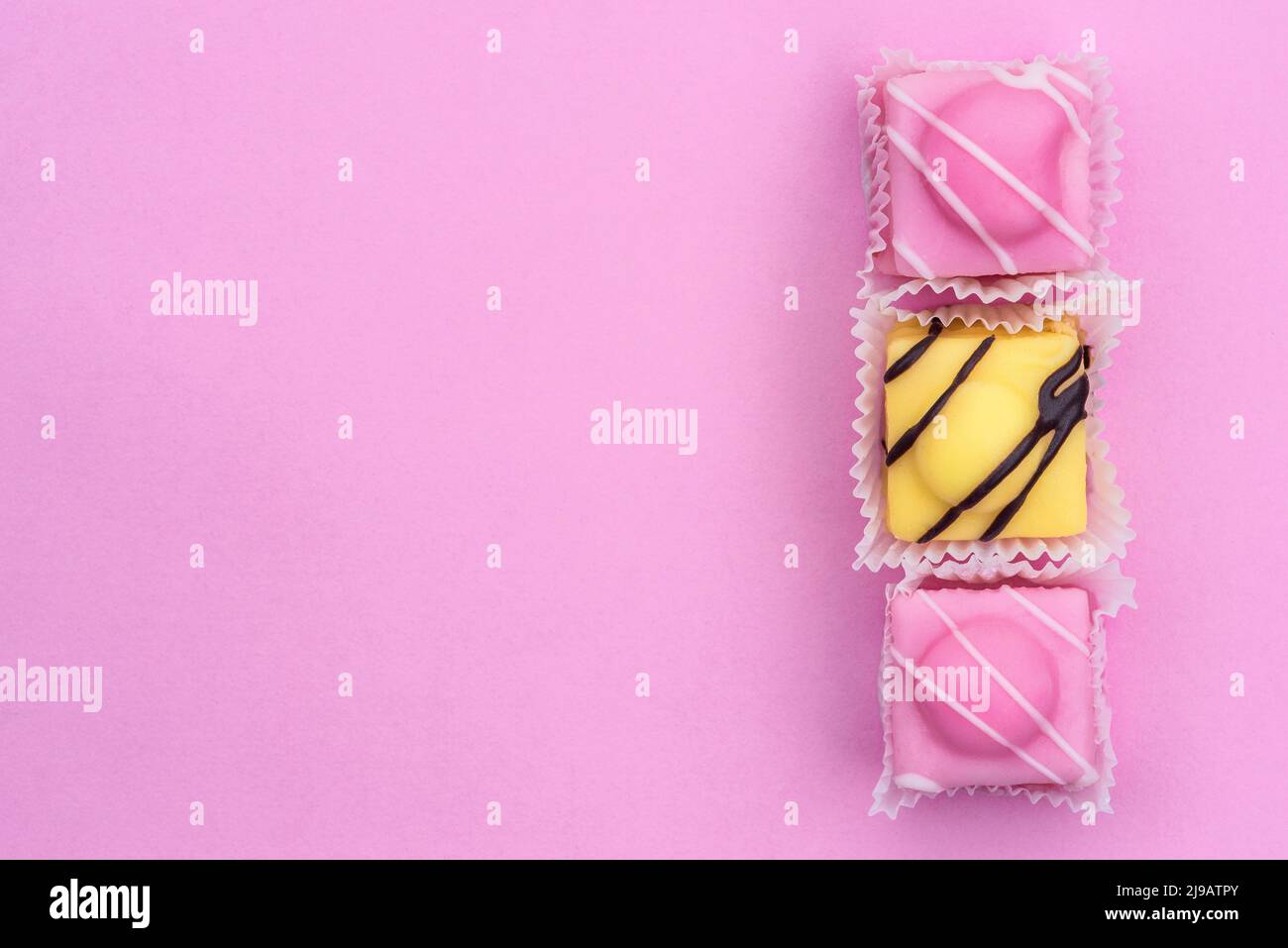 Fondant icing on sponge cakes set on a pastel pink background Stock ...