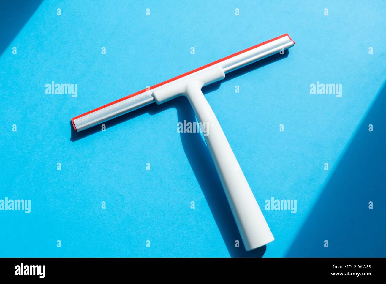 Rubber squeegee for cleaning window on the blue background Stock Photo ...