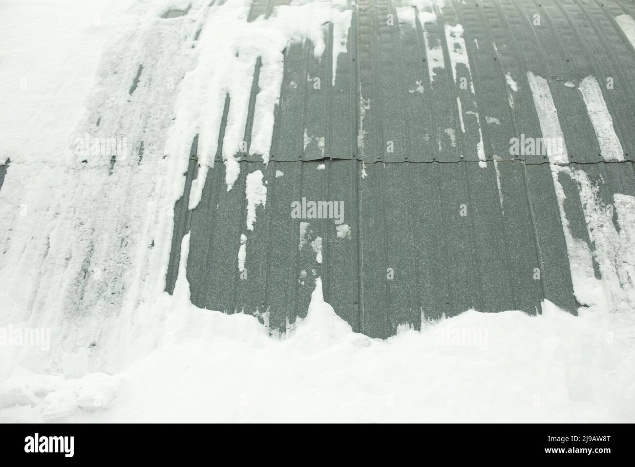 Steel structure in snow. Wall of warehouse after snowstorm. Hedged ...