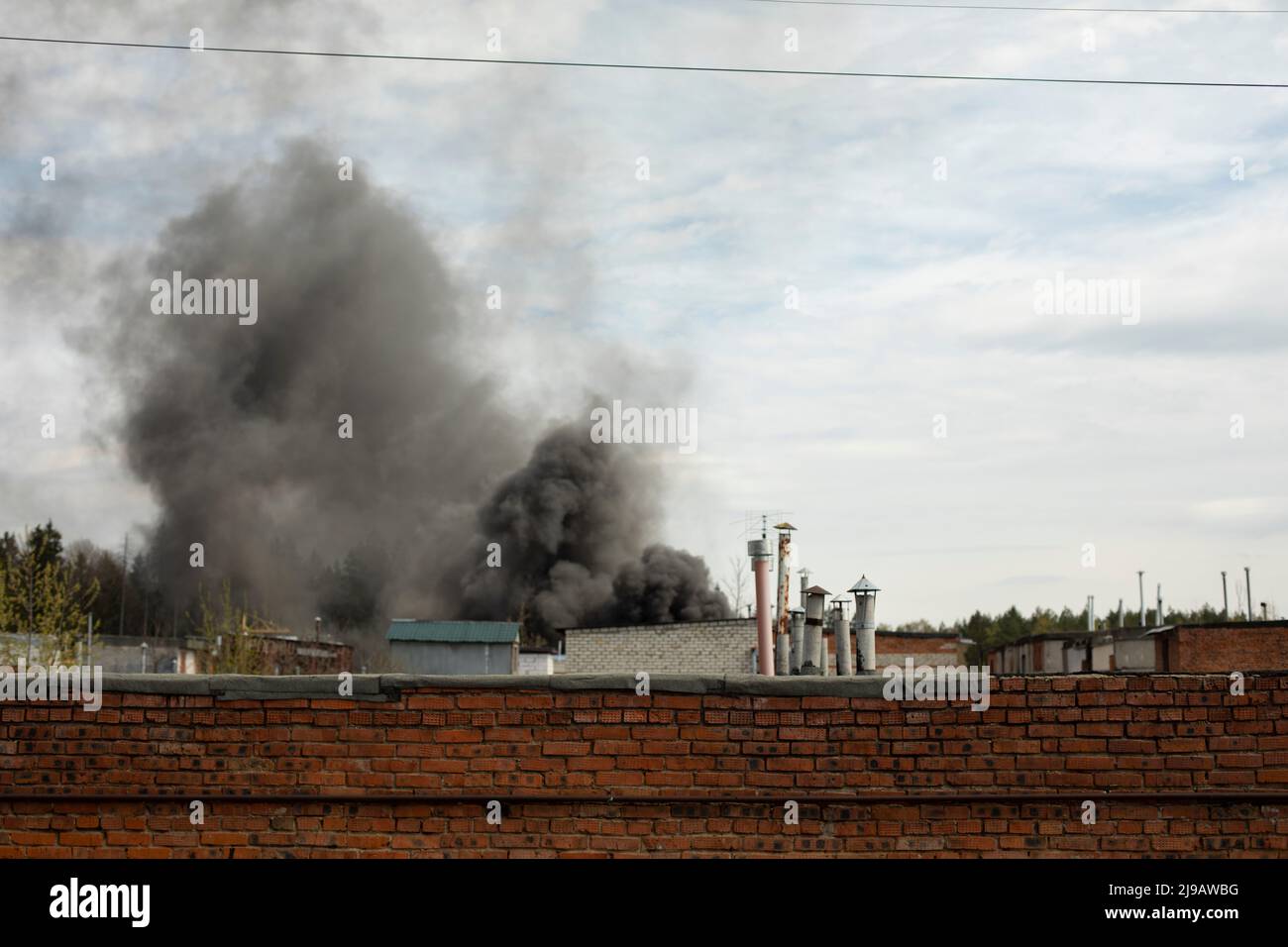 Fire in street. Black smoke against sky. Ignition in garage block ...