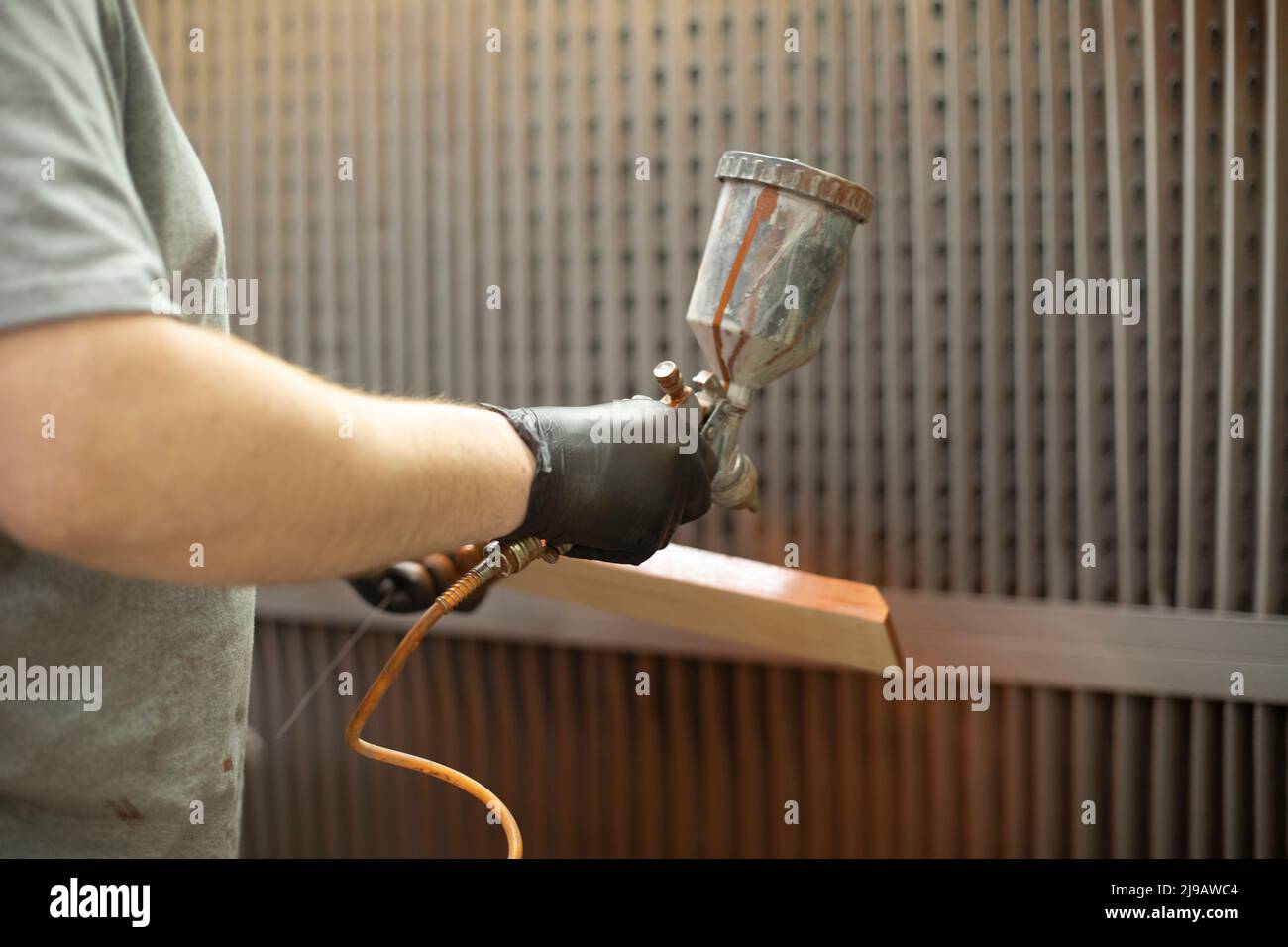 Painting board in black gloves. Spray paint. Creation of furniture ...