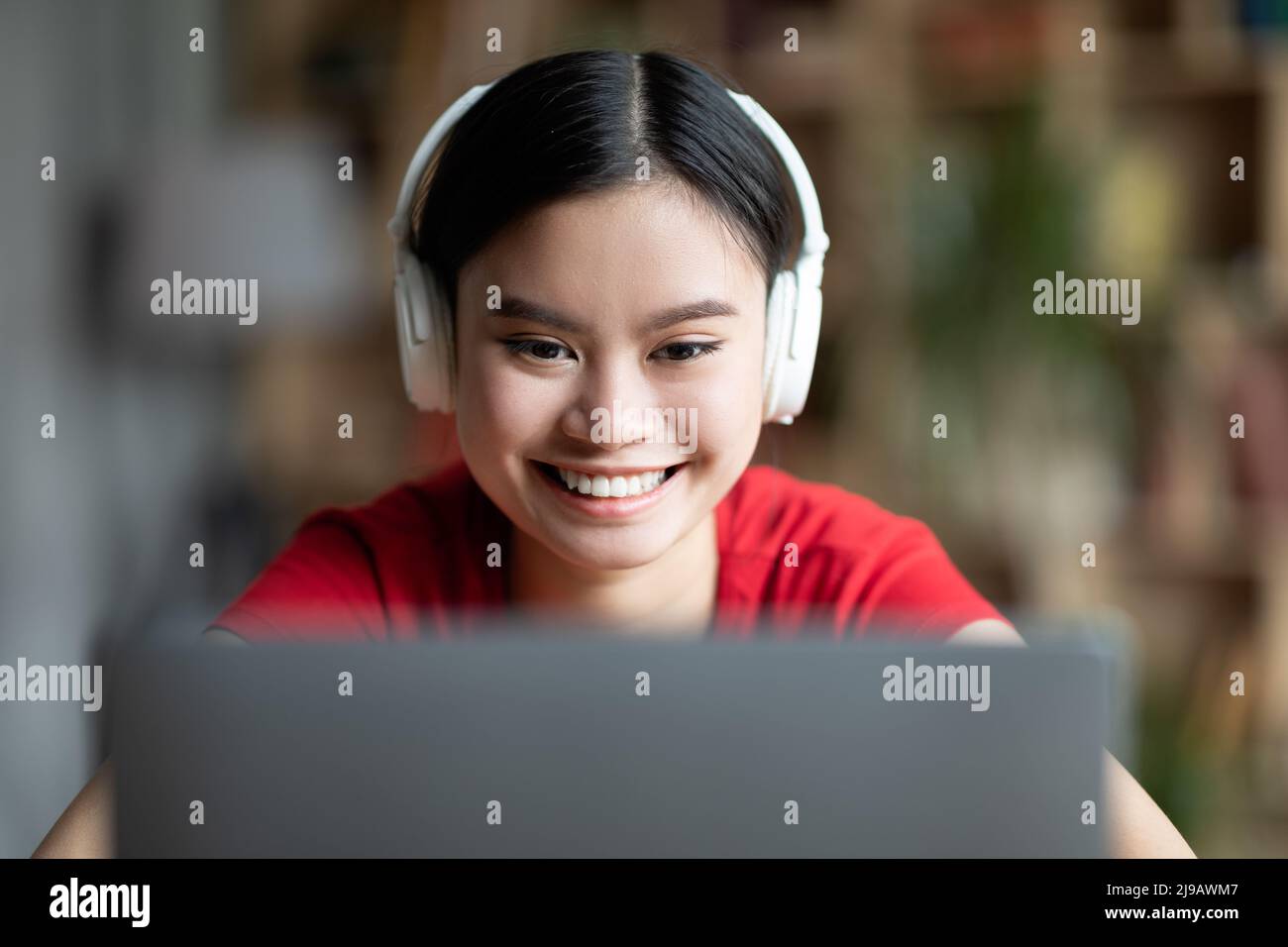 Sad tired young chinese girl student in wireless headphones lies on ...