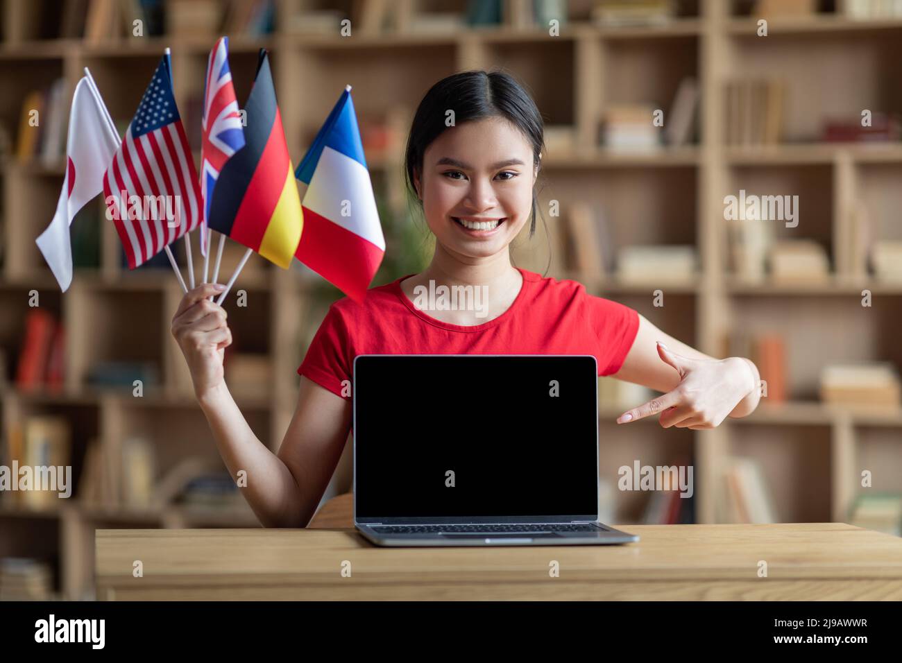 Happy young asian lady student with many international flags show ...