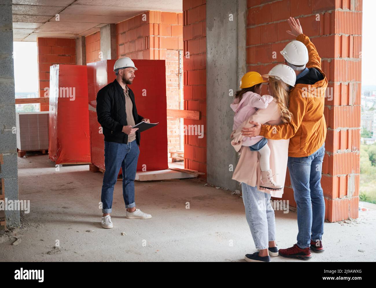 Man and woman with child standing inside apartment building under ...
