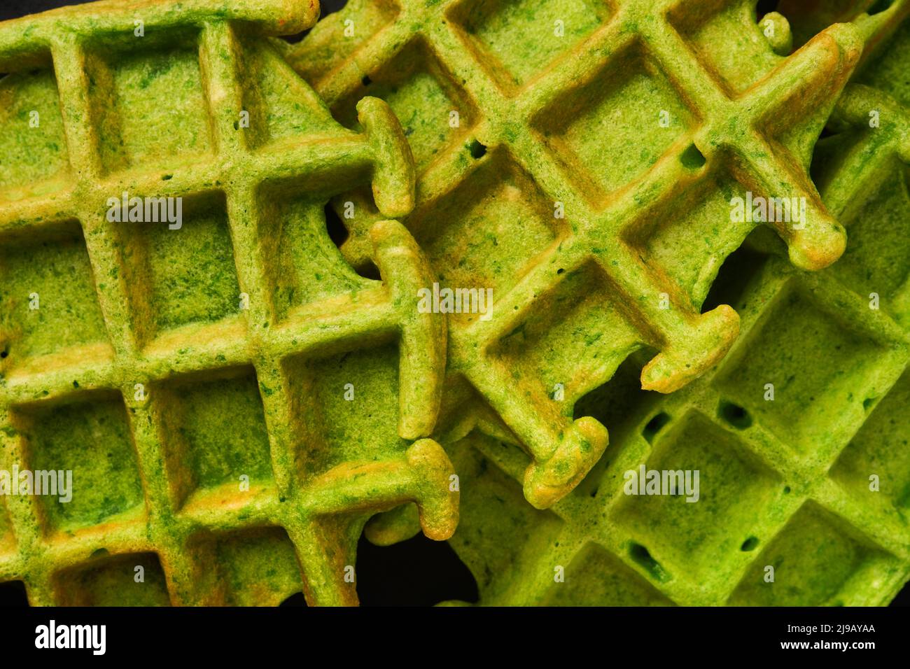 Savory green waffles texture background. Close up of thin hot pancakes ...