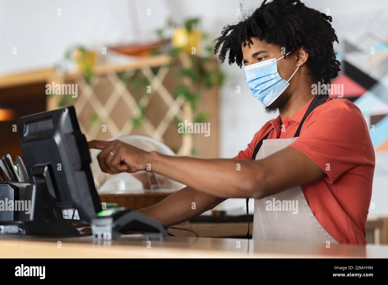Calm curly attractive young black man bartender or waiter in apron ...