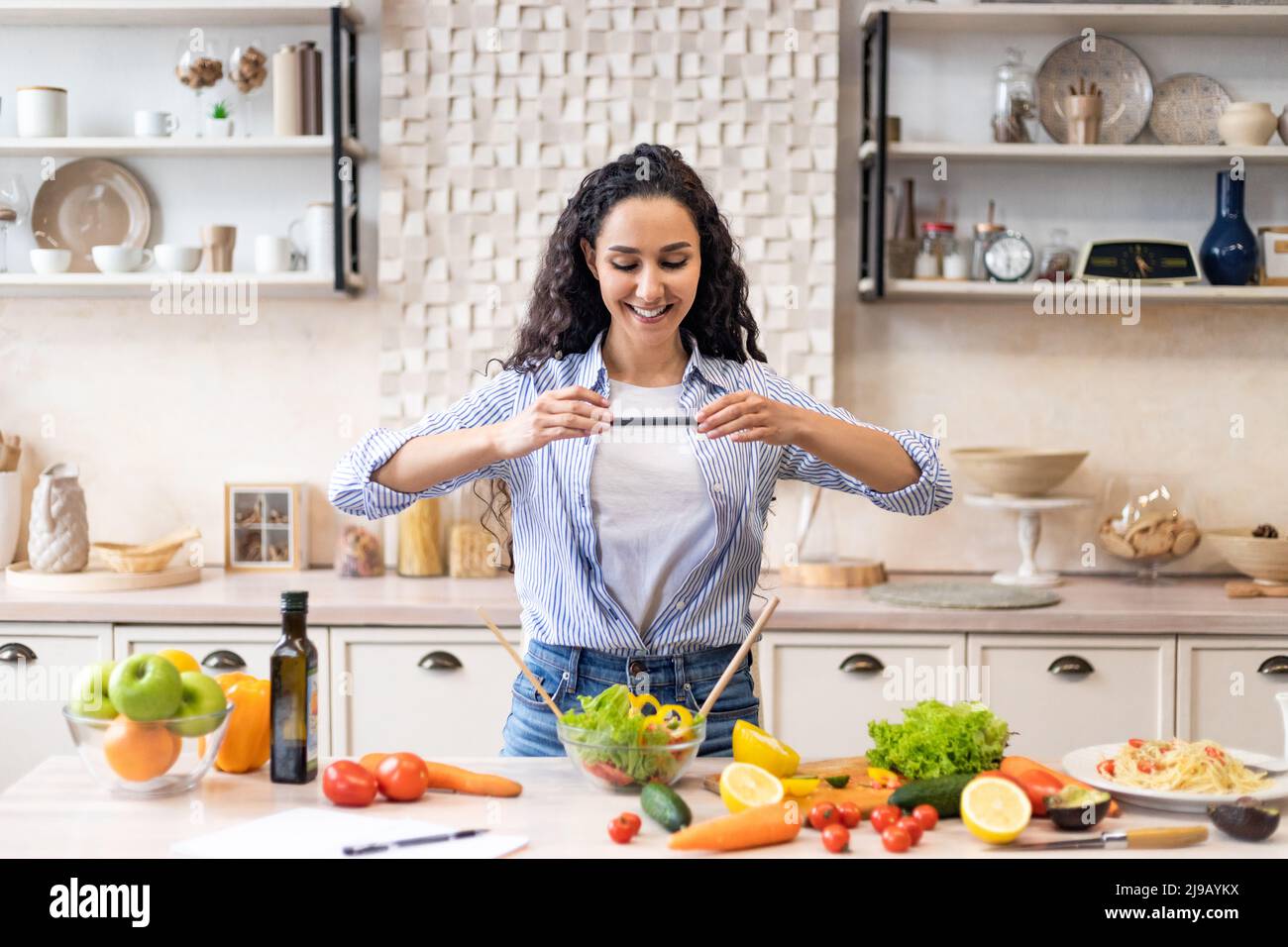 Pretty latin female blogger making photo of salad for food blog ...
