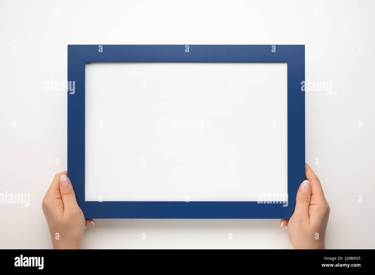 Holding frame mockup. Photo Mockup. Woman hands hold blue frame. For ...