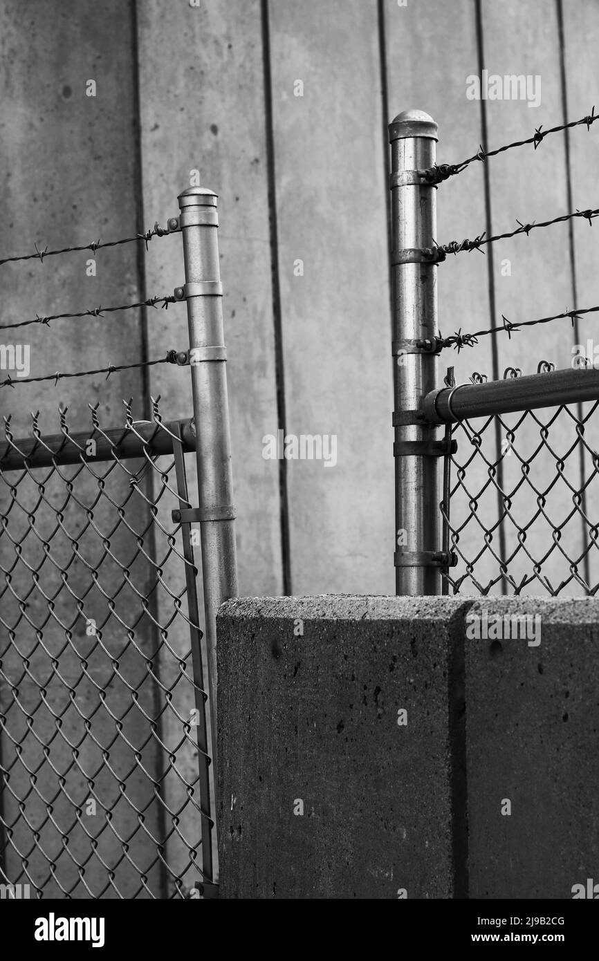 Barbed wire fence protecting something important in black and white ...