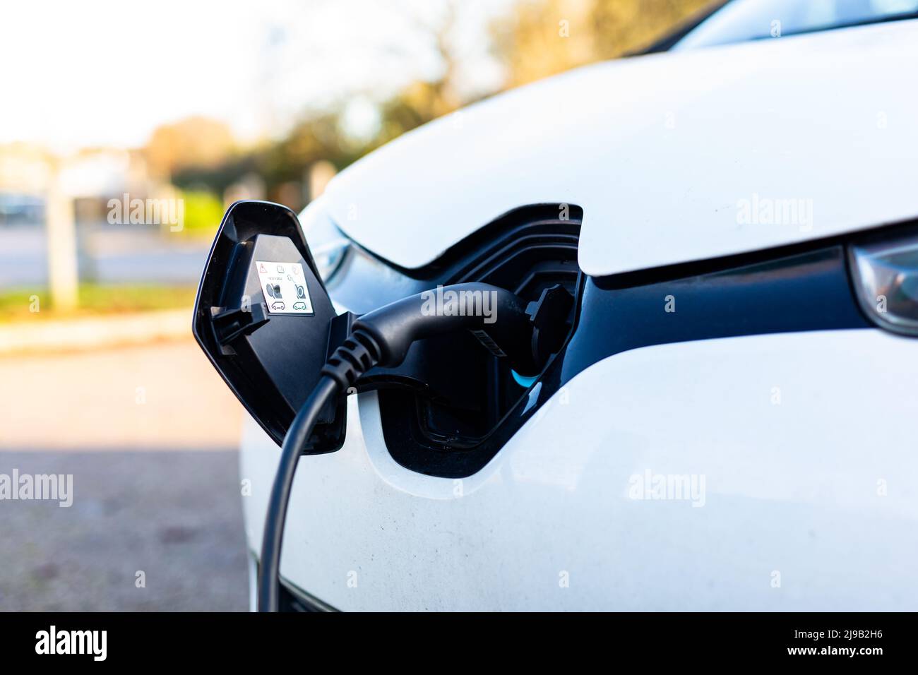 Electric car charging at plug-in charge station in a public car park in ...
