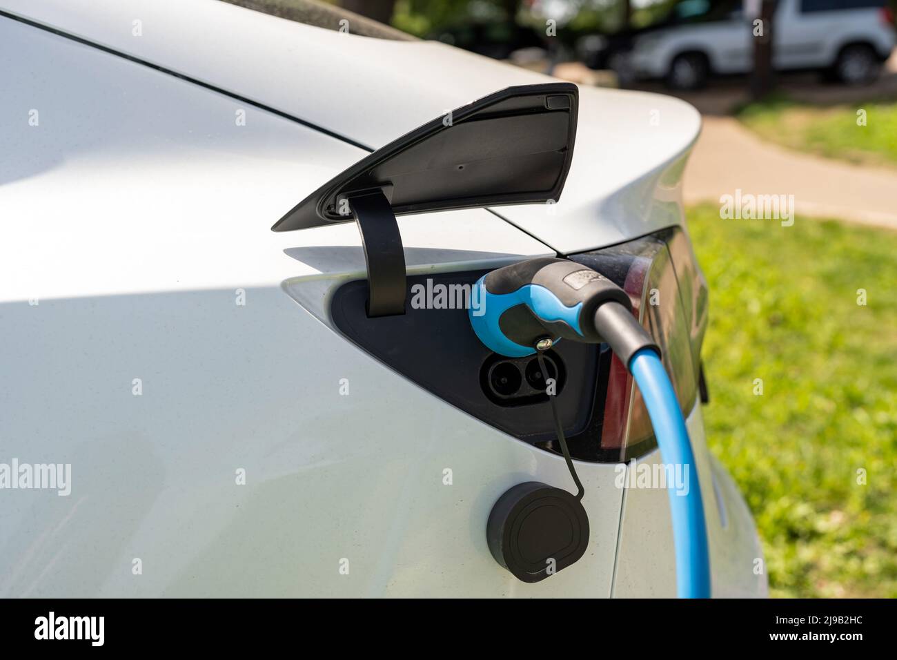 Electric car charging at plug-in charge station in a public car park in ...