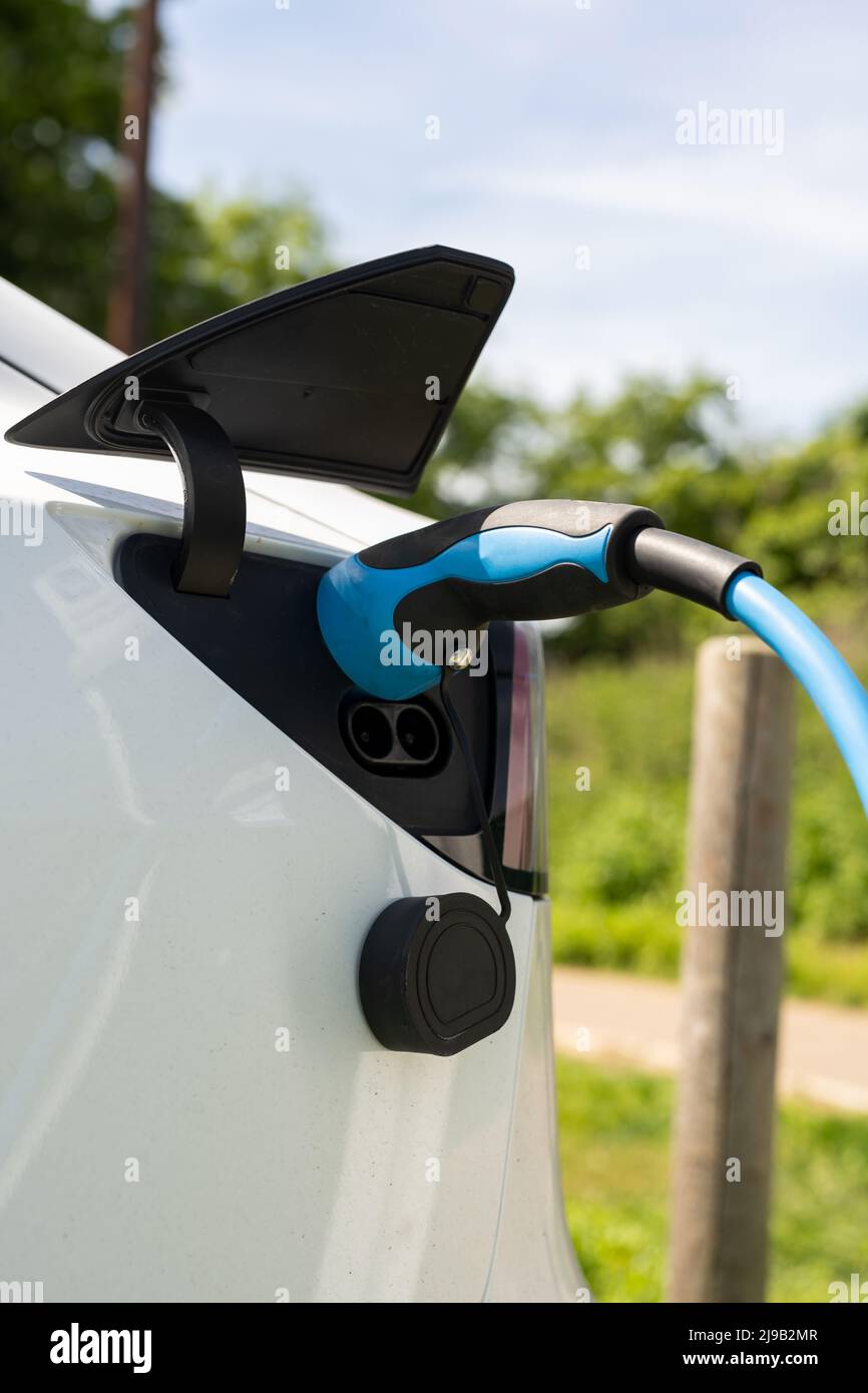 Electric car charging at plug-in charge station in a public car park in ...