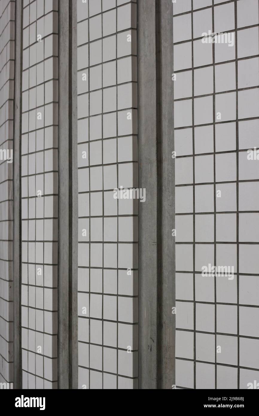 Square tiles on a wall in a grid repeat pattern in black and white ...