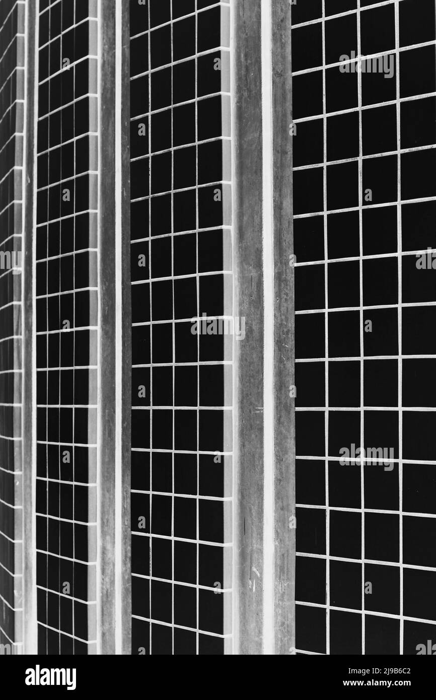 Square tiles on a wall in a grid repeat pattern in black and white film ...