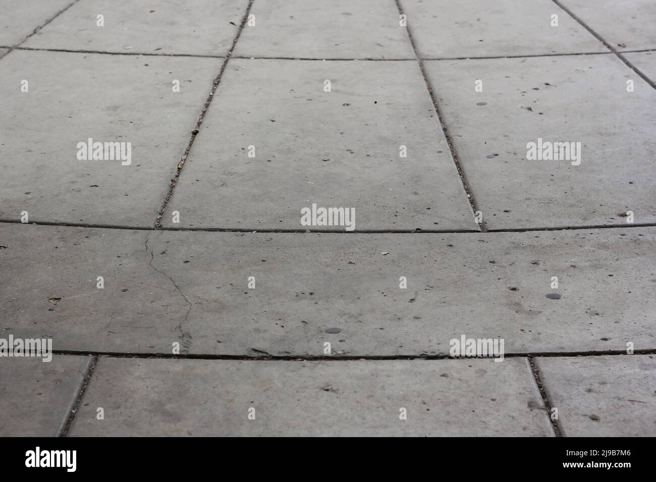 A minimalist view of a concrete panel floor with a radial pattern in ...