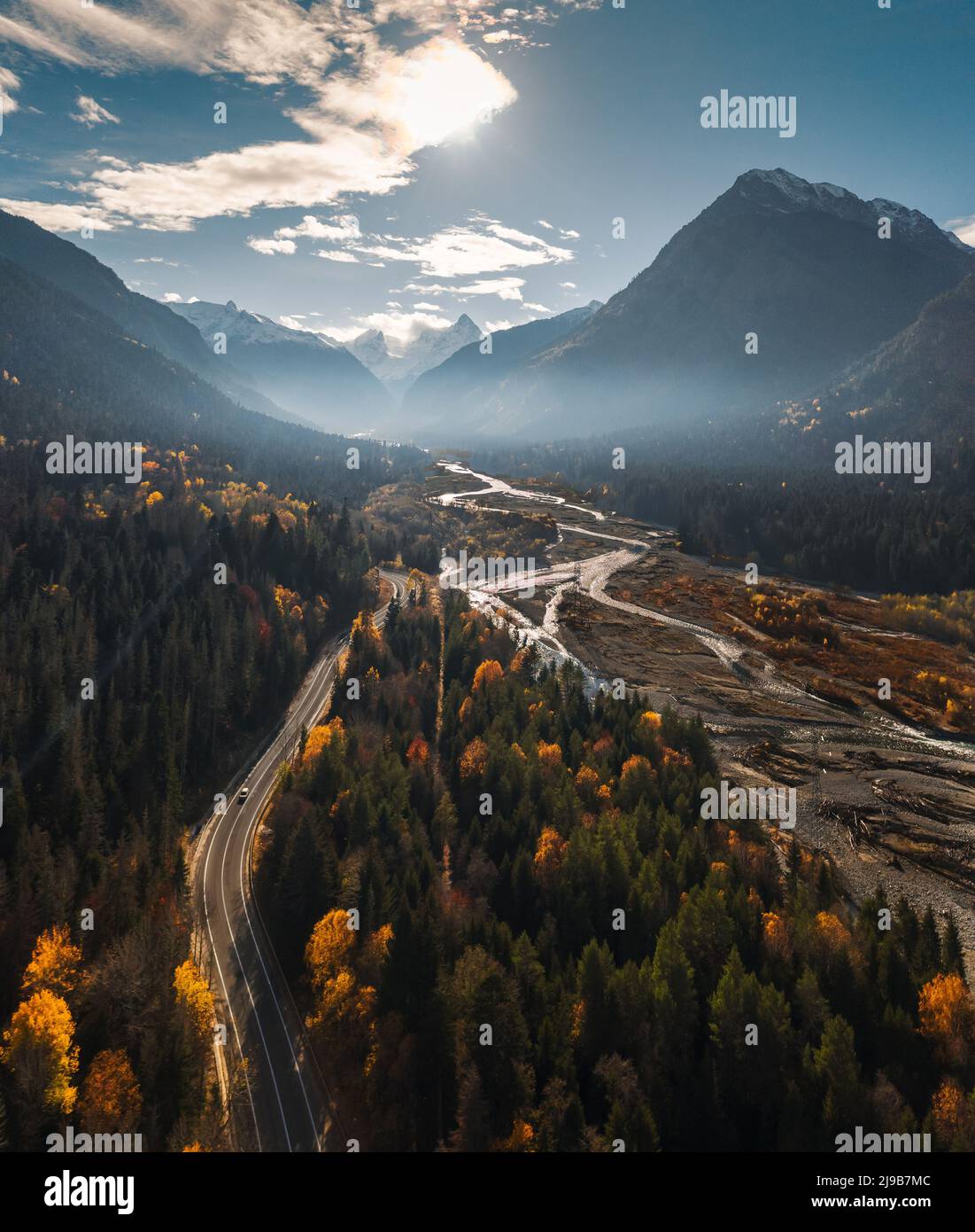 High angle aerial view of river and road running through forest and ...