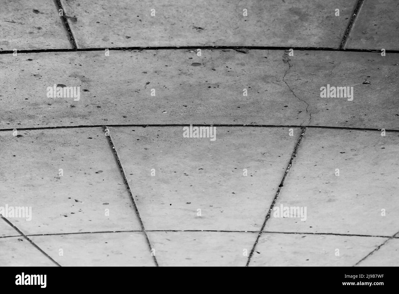 A minimalist view of a concrete panel floor with a radial pattern in ...