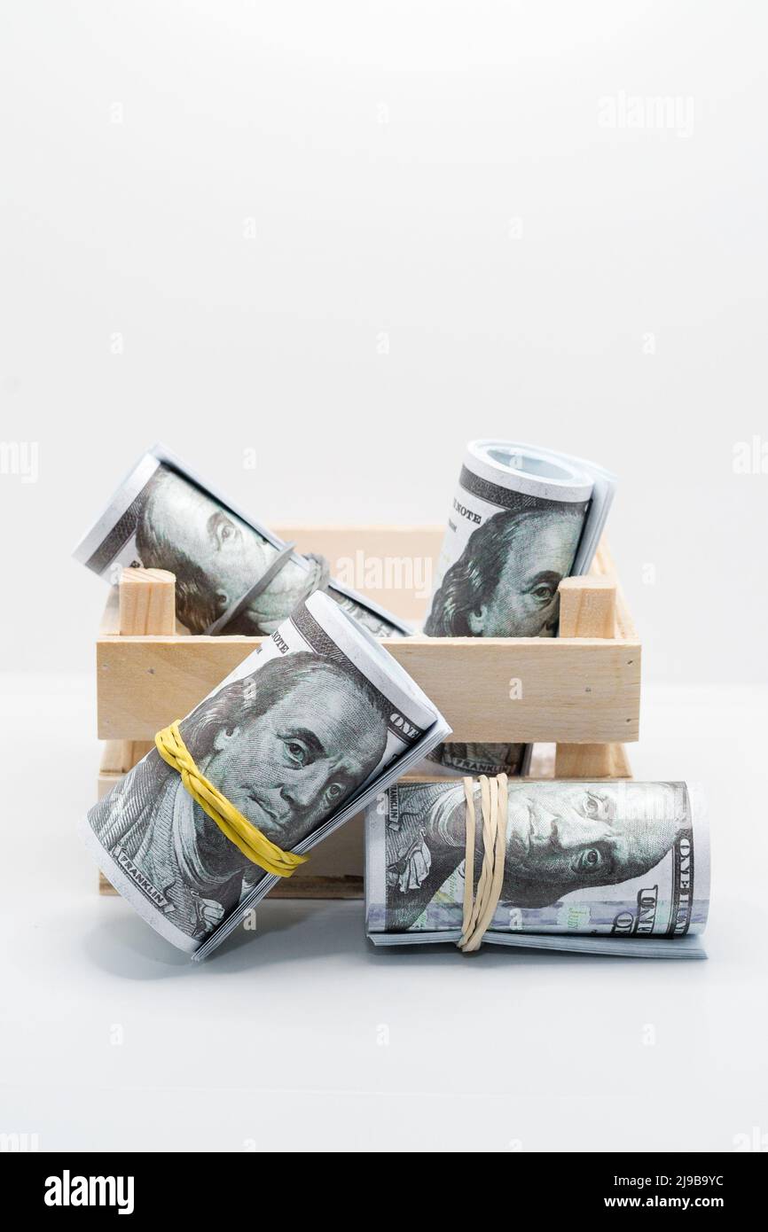 A small wooden box with paper dollar bills on a white background Stock ...