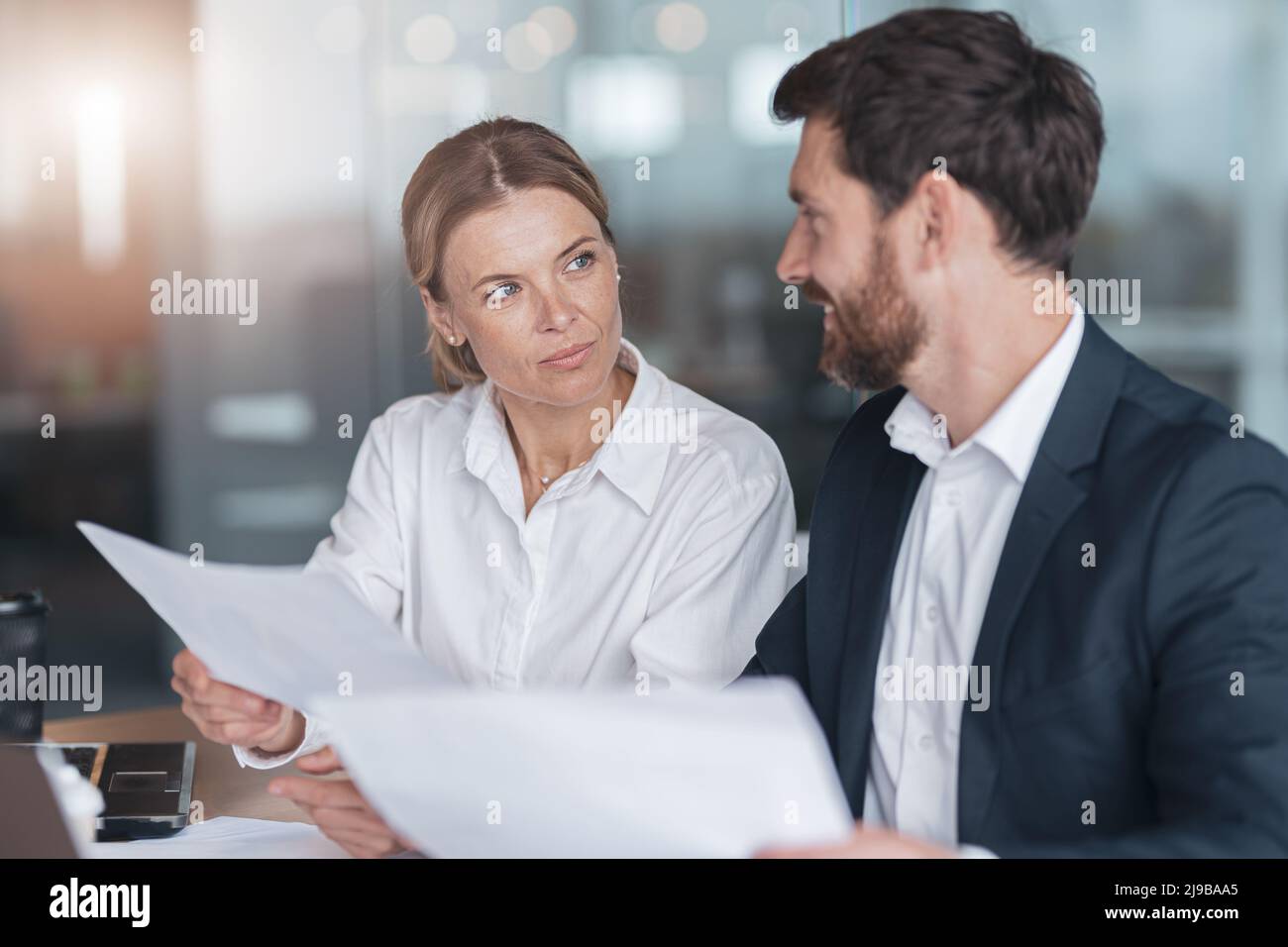 Two business people in modern office explaining statistics data to each ...