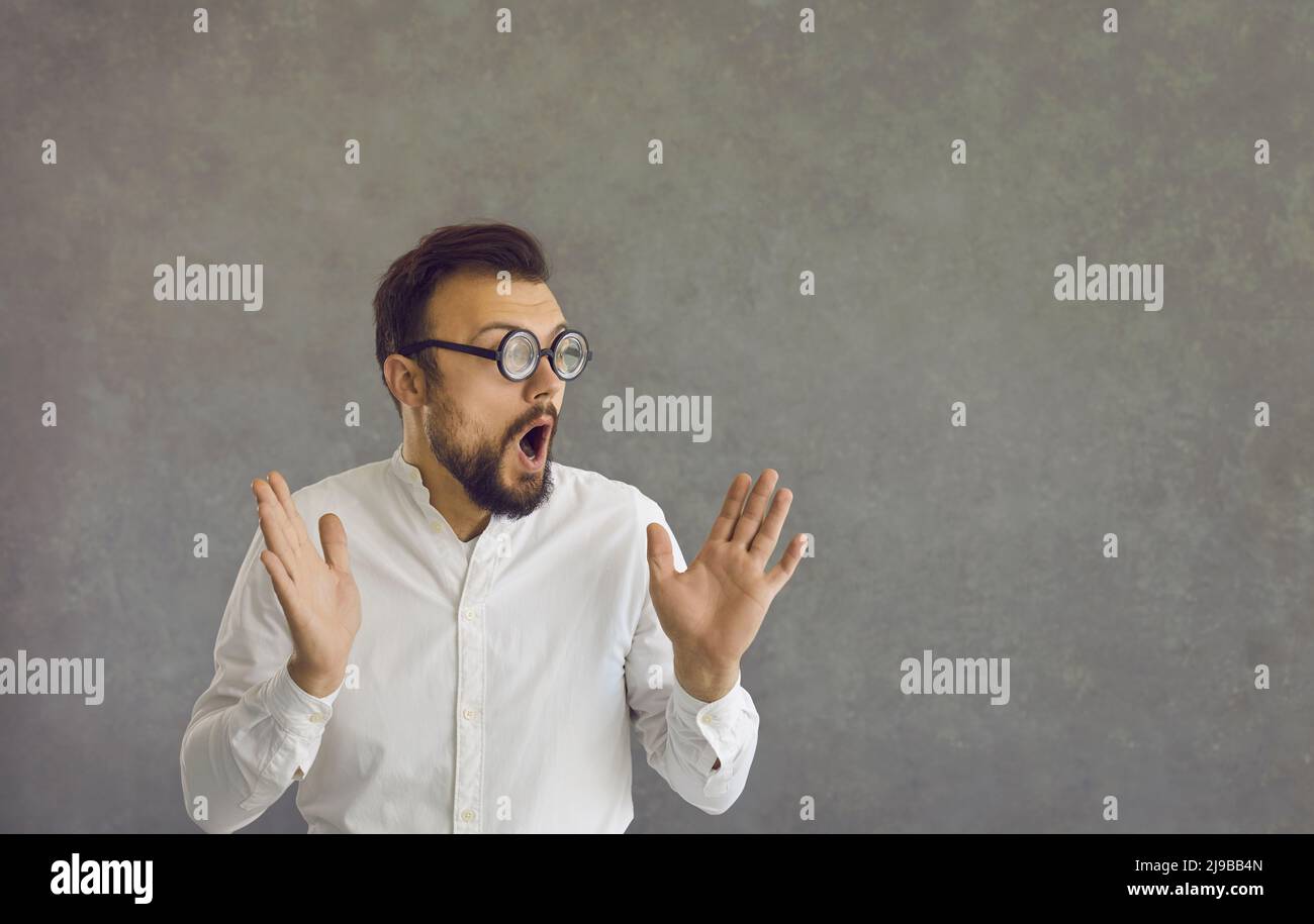 Portrait of funny nerd man in glasses with surprised facial expression ...