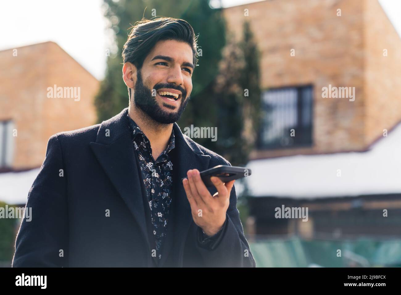medium portrait of young Latin man thinking while talking on the phone ...