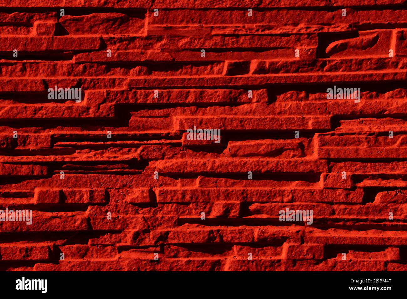 Bright red narrow stone wall background texture Stock Photo - Alamy