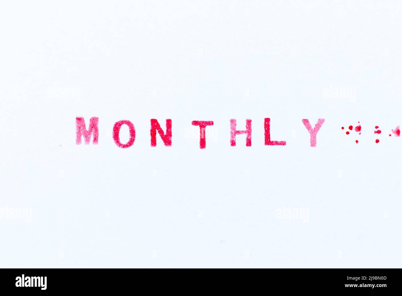Red color ink rubber stamp in word monthly on white paper background ...