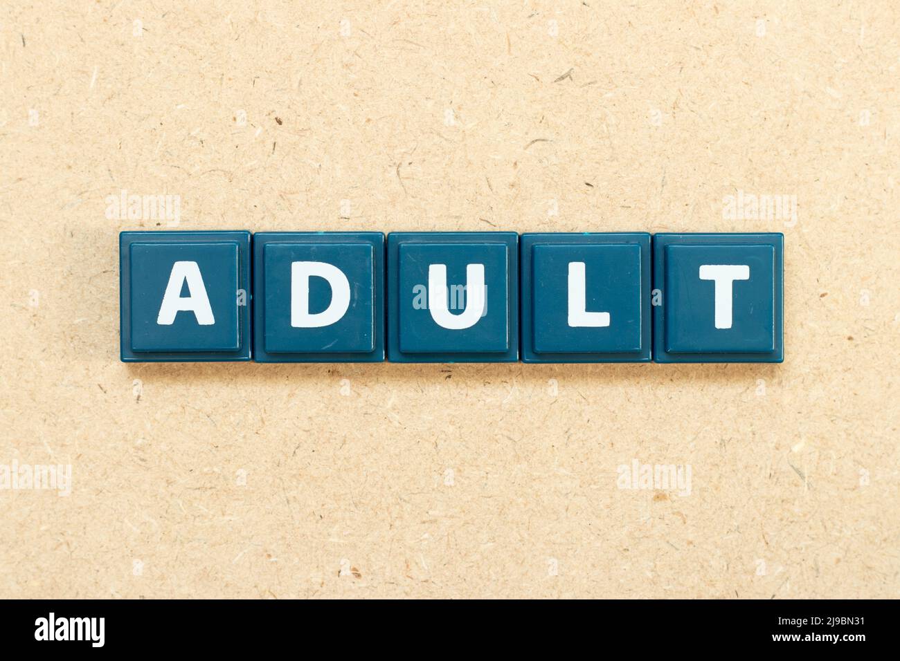 Tile alphabet letter in word adult on wood background Stock Photo - Alamy