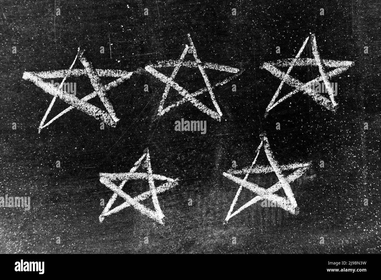 White chalk drawing in star shape on black board background Stock Photo ...