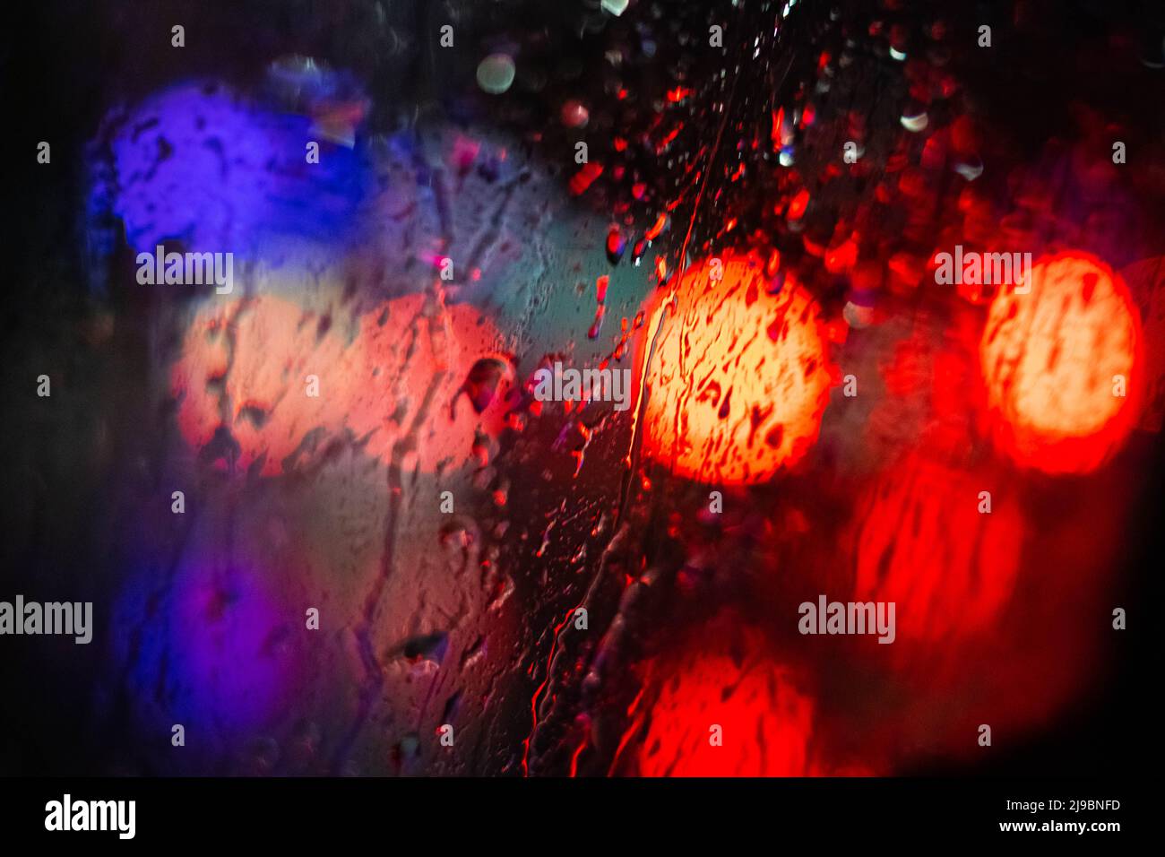bokeh lights of cars behind window - traffic at night concept ...