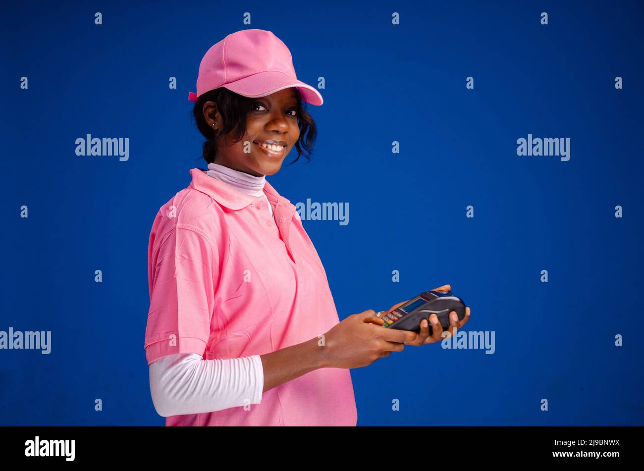 lady smiling as holds her point of sales device Stock Photo - Alamy