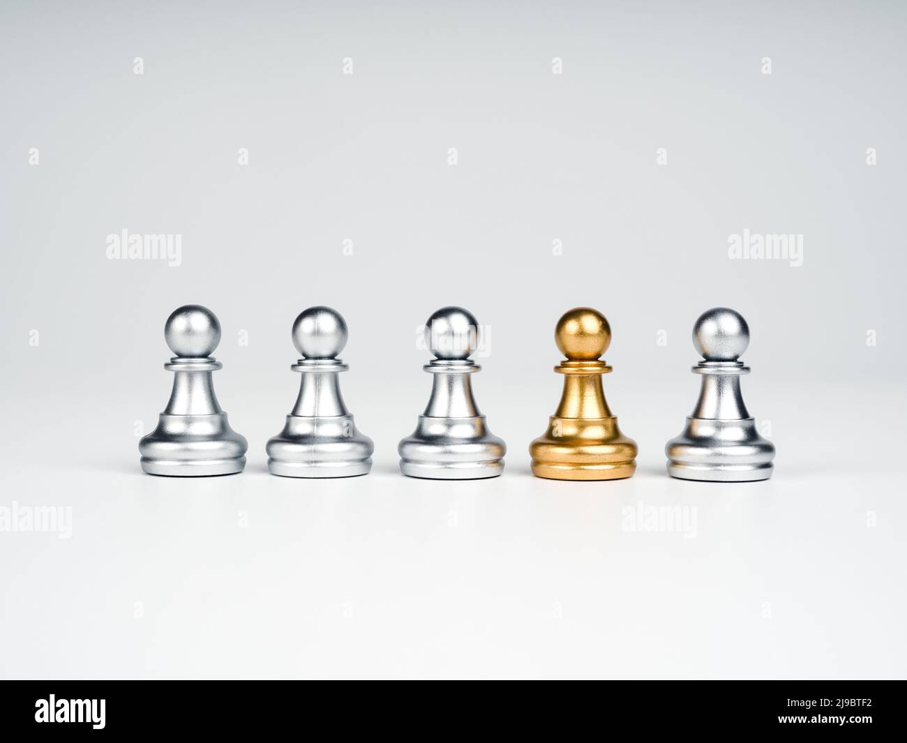 The golden pawn chess piece standing out of the group of silver pawn ...