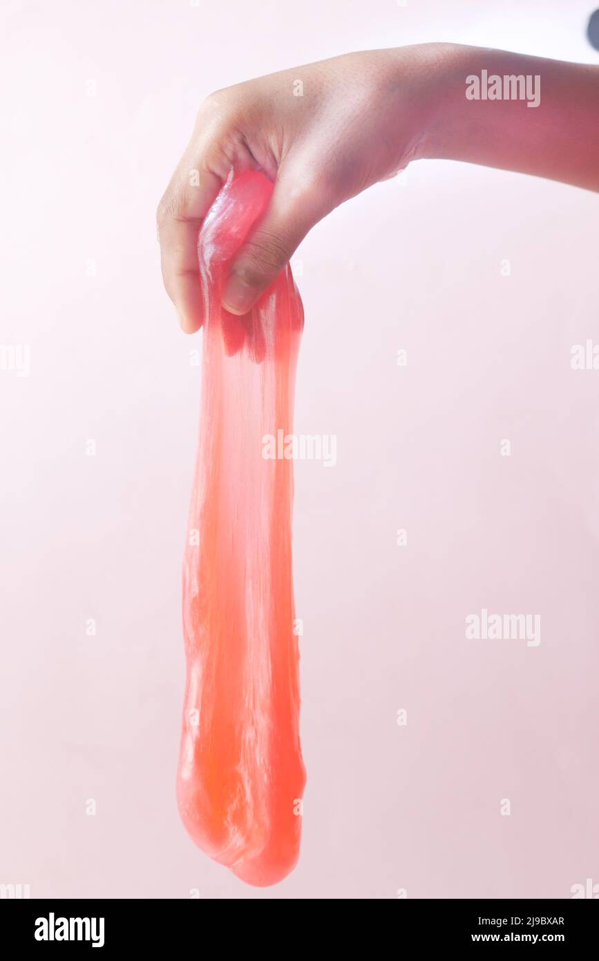 child Hand holding pink color slime Stock Photo - Alamy