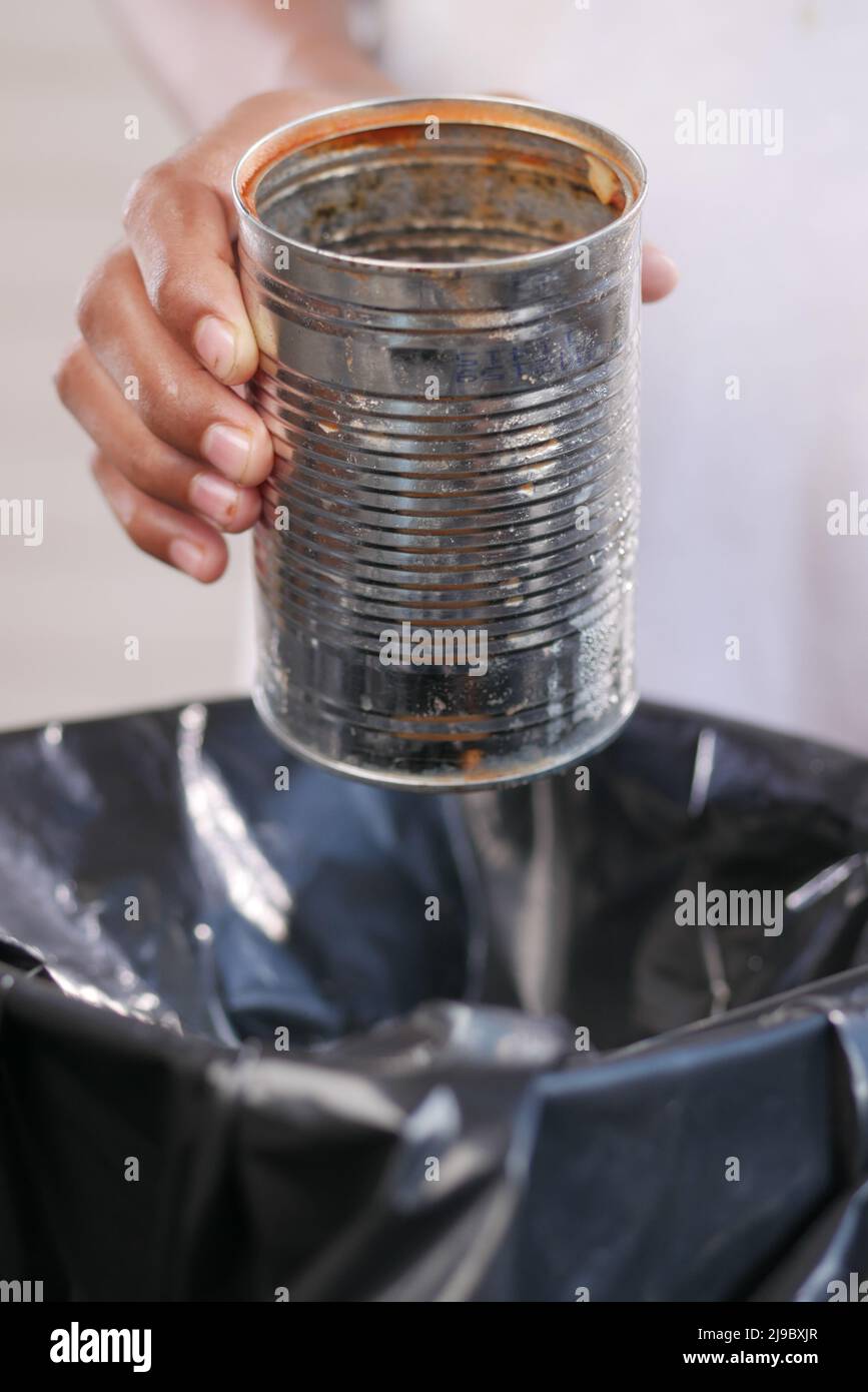 throwing tin container in a garbage bin Stock Photo - Alamy
